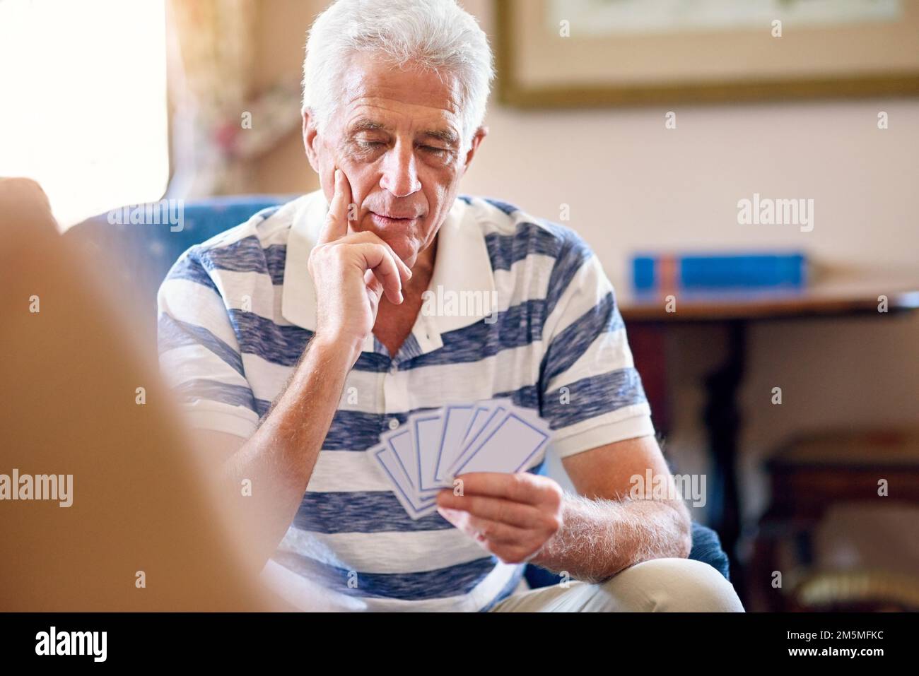 Now I just need to play my cards right. a happy senior man looking at ...