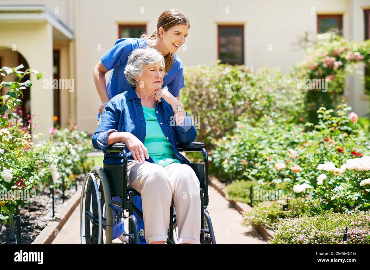 Where to next. a resident and a nurse outside in the retirement home ...