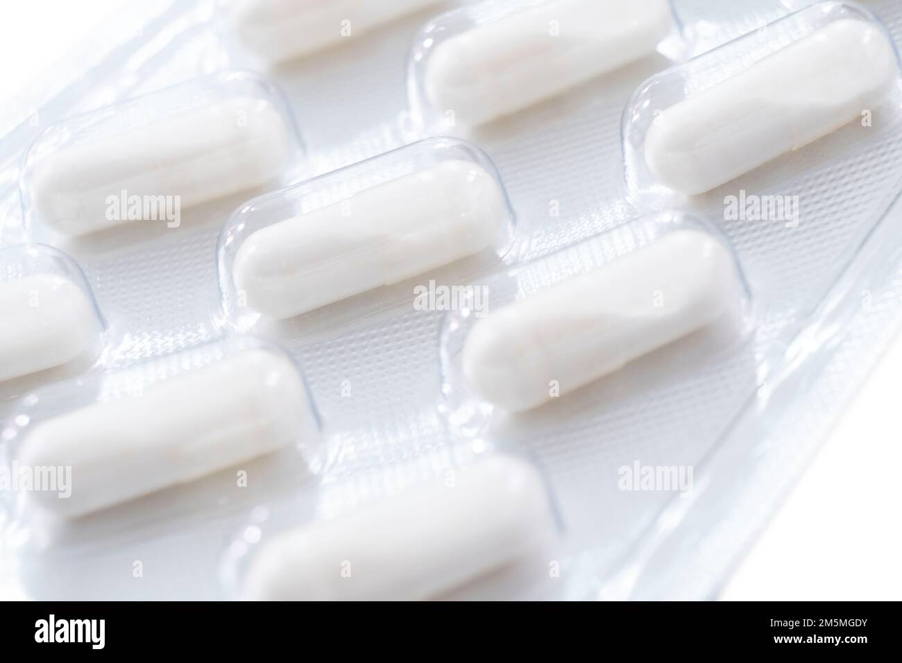Macro shot pile of tablets pill in silver blister packaging isolated on ...