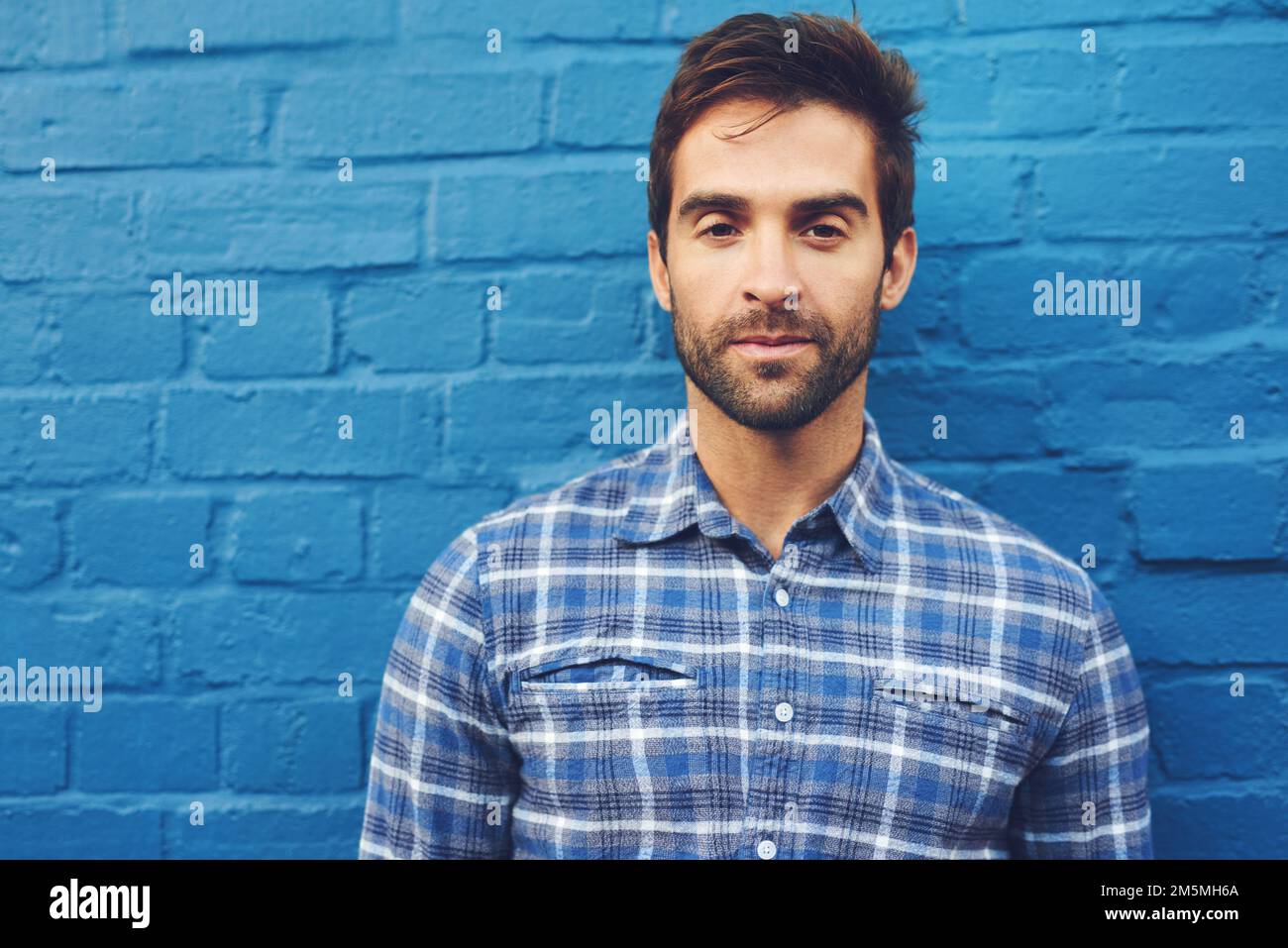He makes this wall look good. a handsome young man posing against a ...