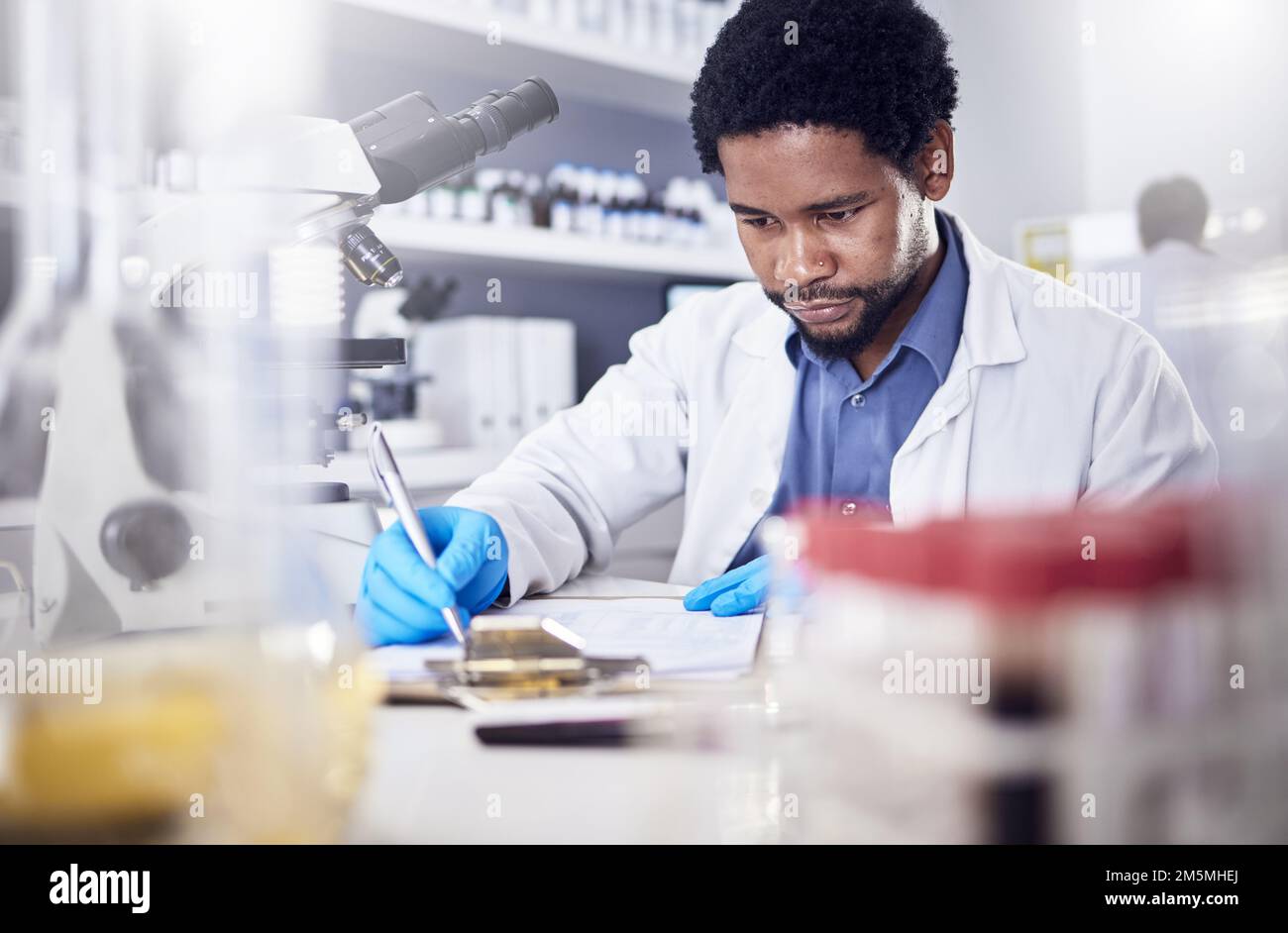Black man writing report for science study, scientist in lab for ...