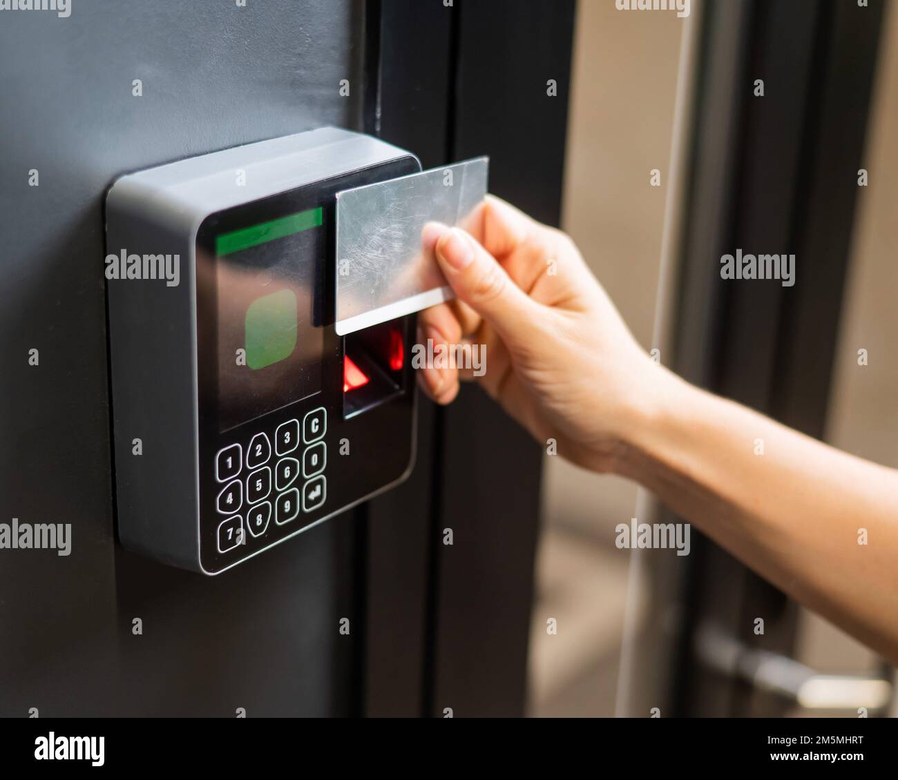 A woman opens the door with a plastic card. Modern keyless entry lock ...