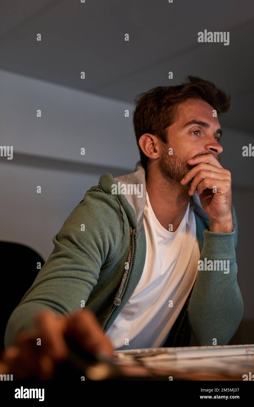 Pulling an all-nighter. a young designer working late in the office ...