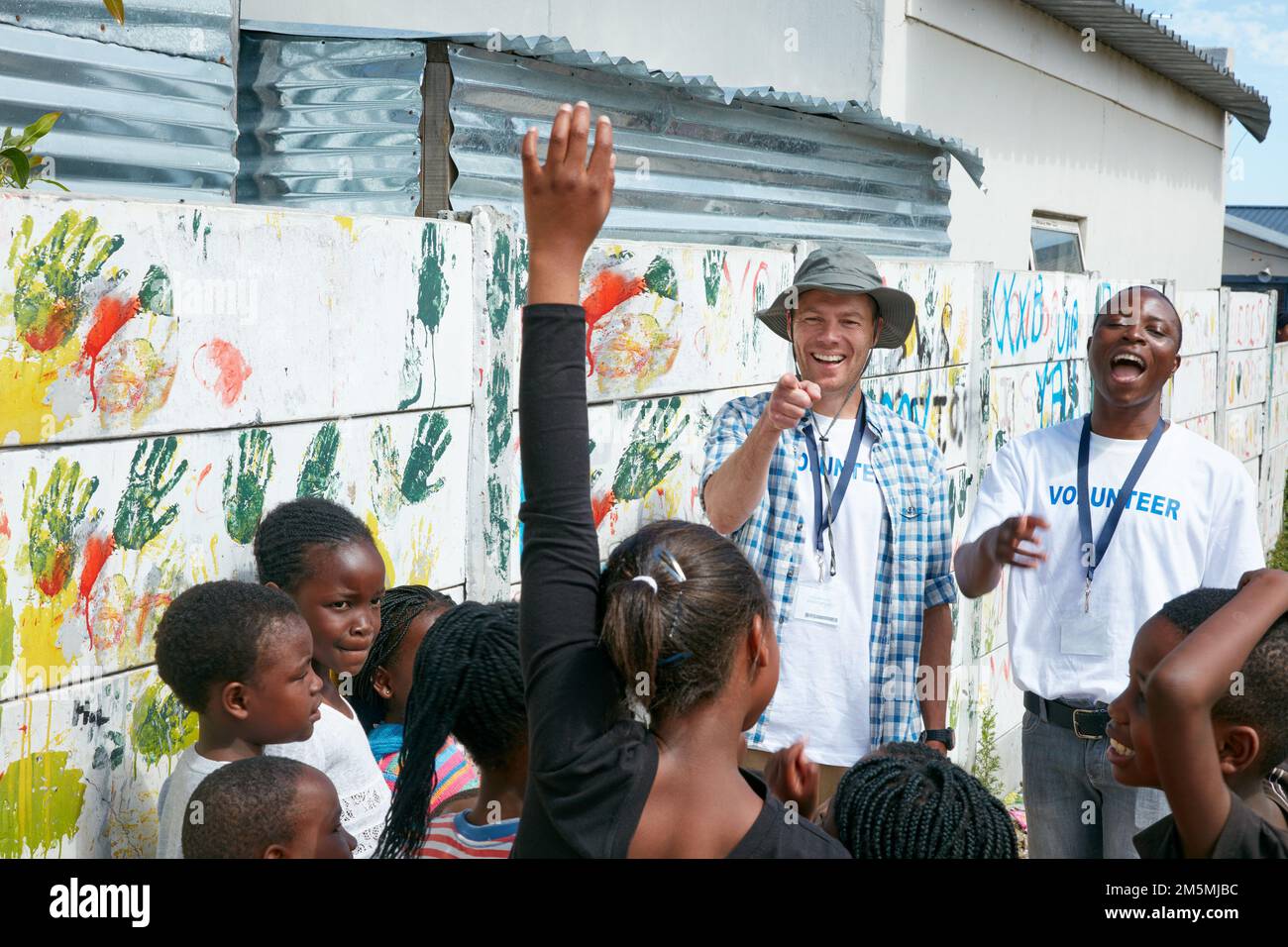 Ask away. volunteer workers addressing a group of children at a ...