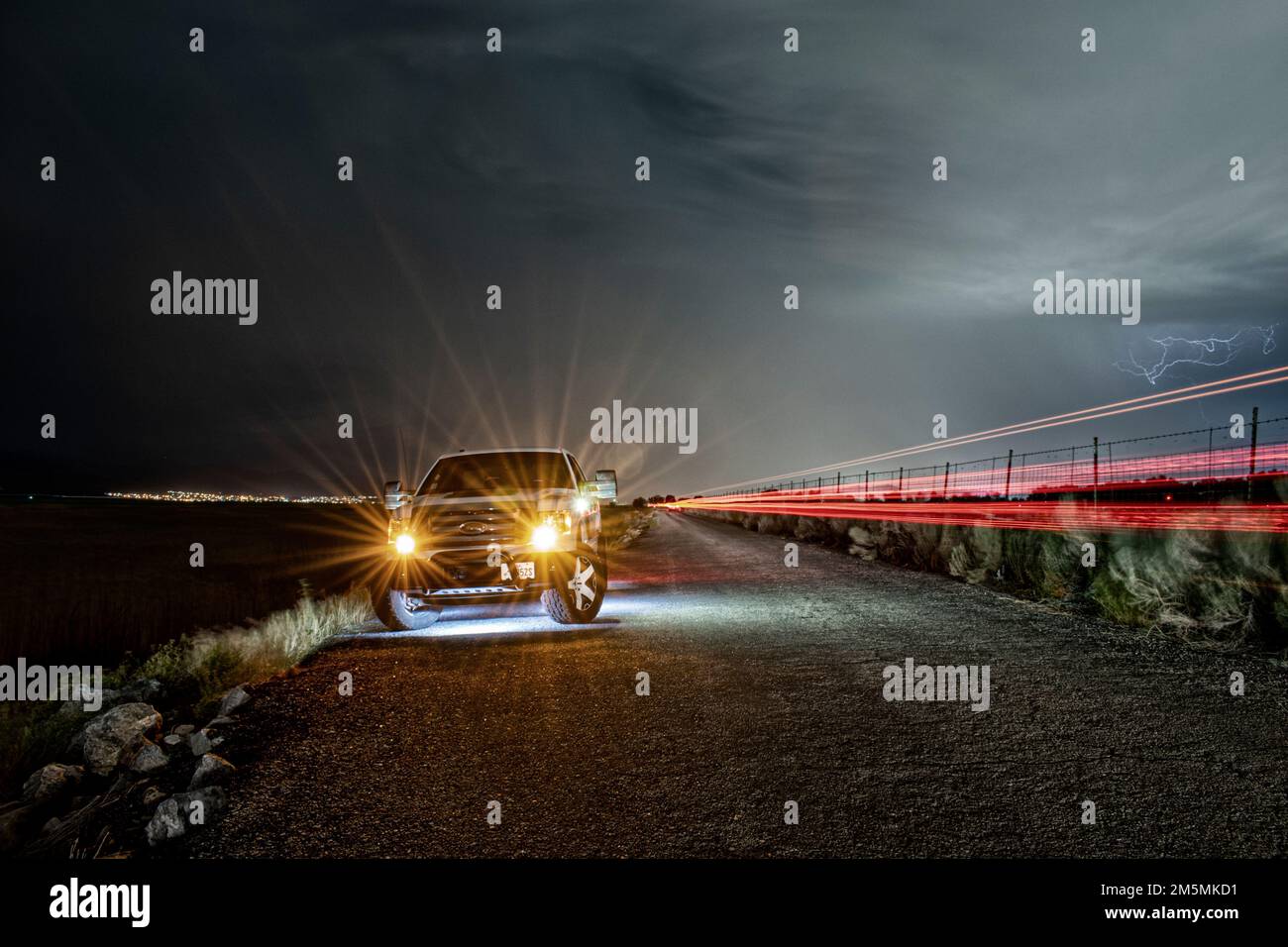 A side view of a Ford F150 parked on the street during storm shot in ...
