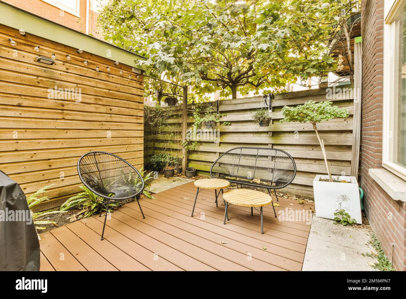 a backyard area with two chairs and a table on the deck, surrounded by ...