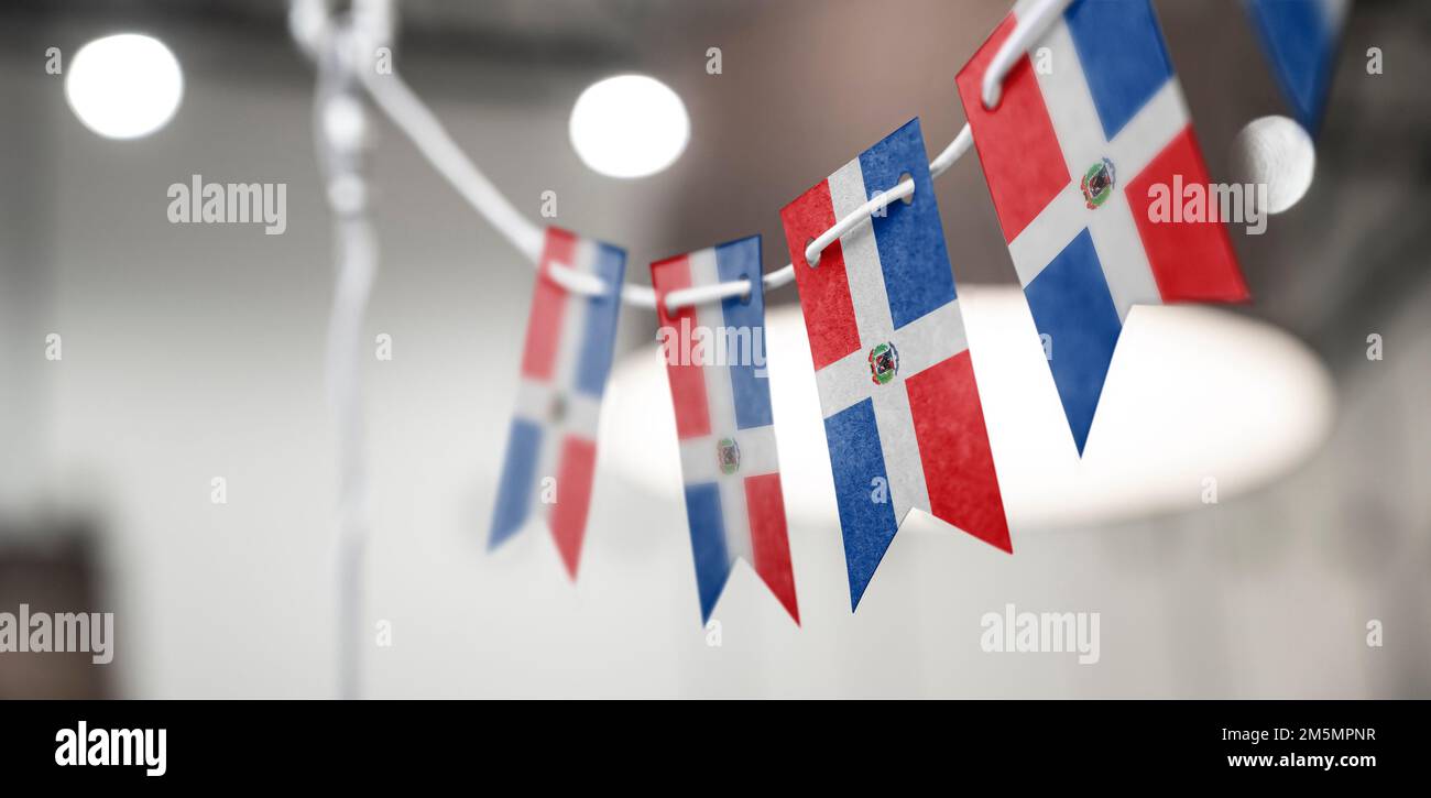A garland of Dominicana national flags on an abstract blurred ...