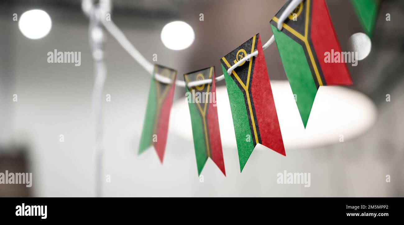 A garland of Vanuatu national flags on an abstract blurred background ...