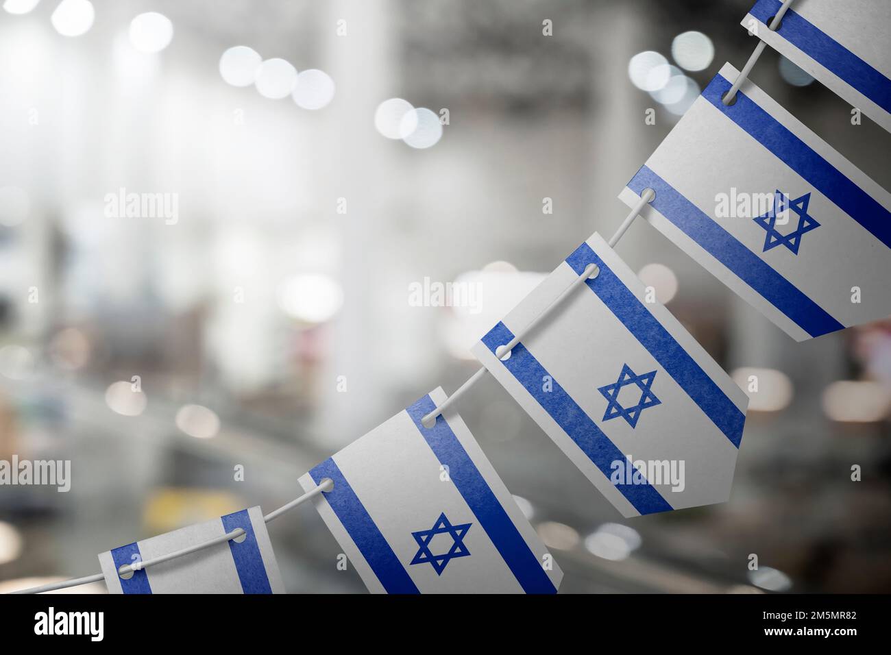 A garland of Israel national flags on an abstract blurred background ...