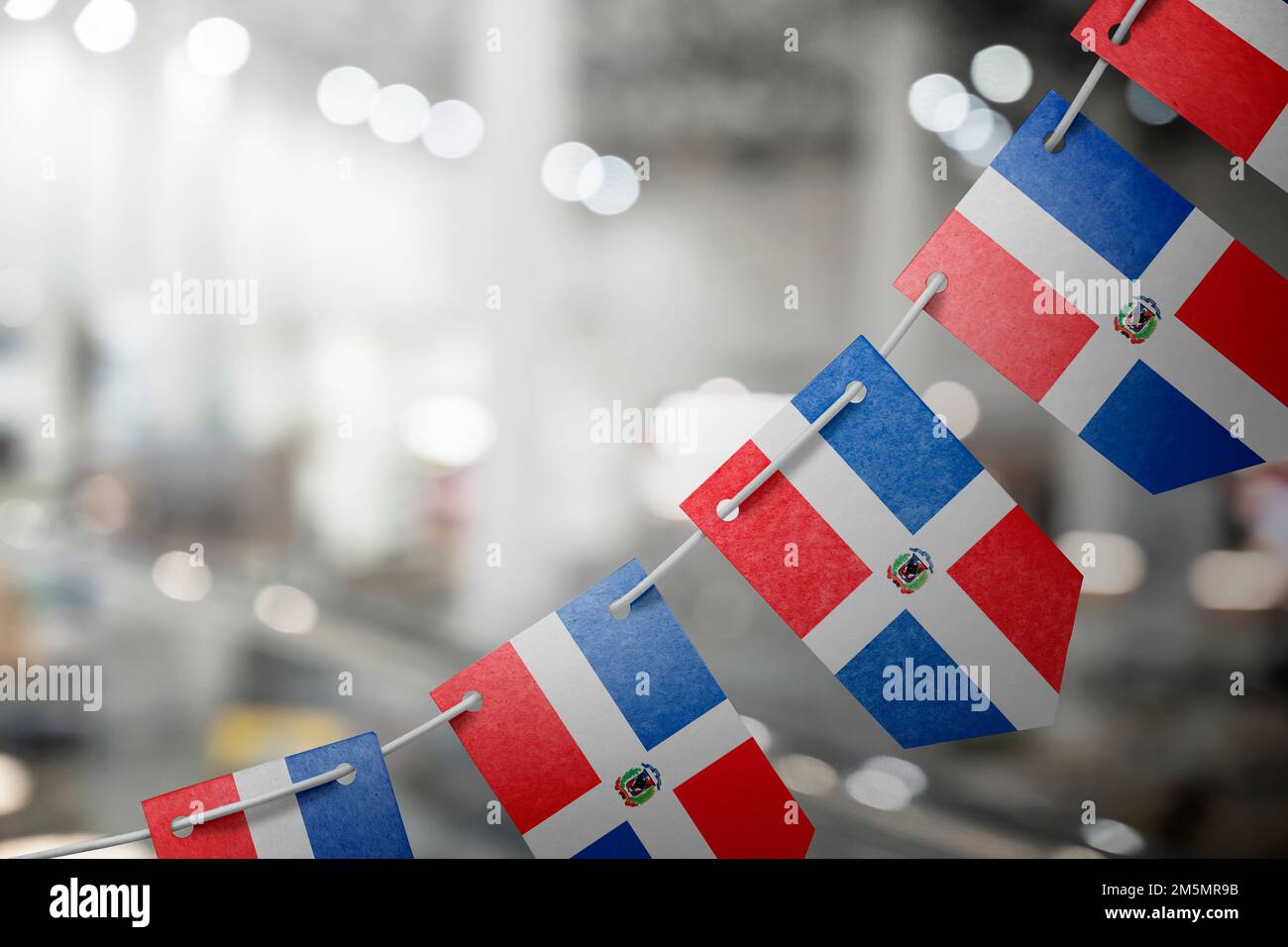 A garland of Dominicana national flags on an abstract blurred ...