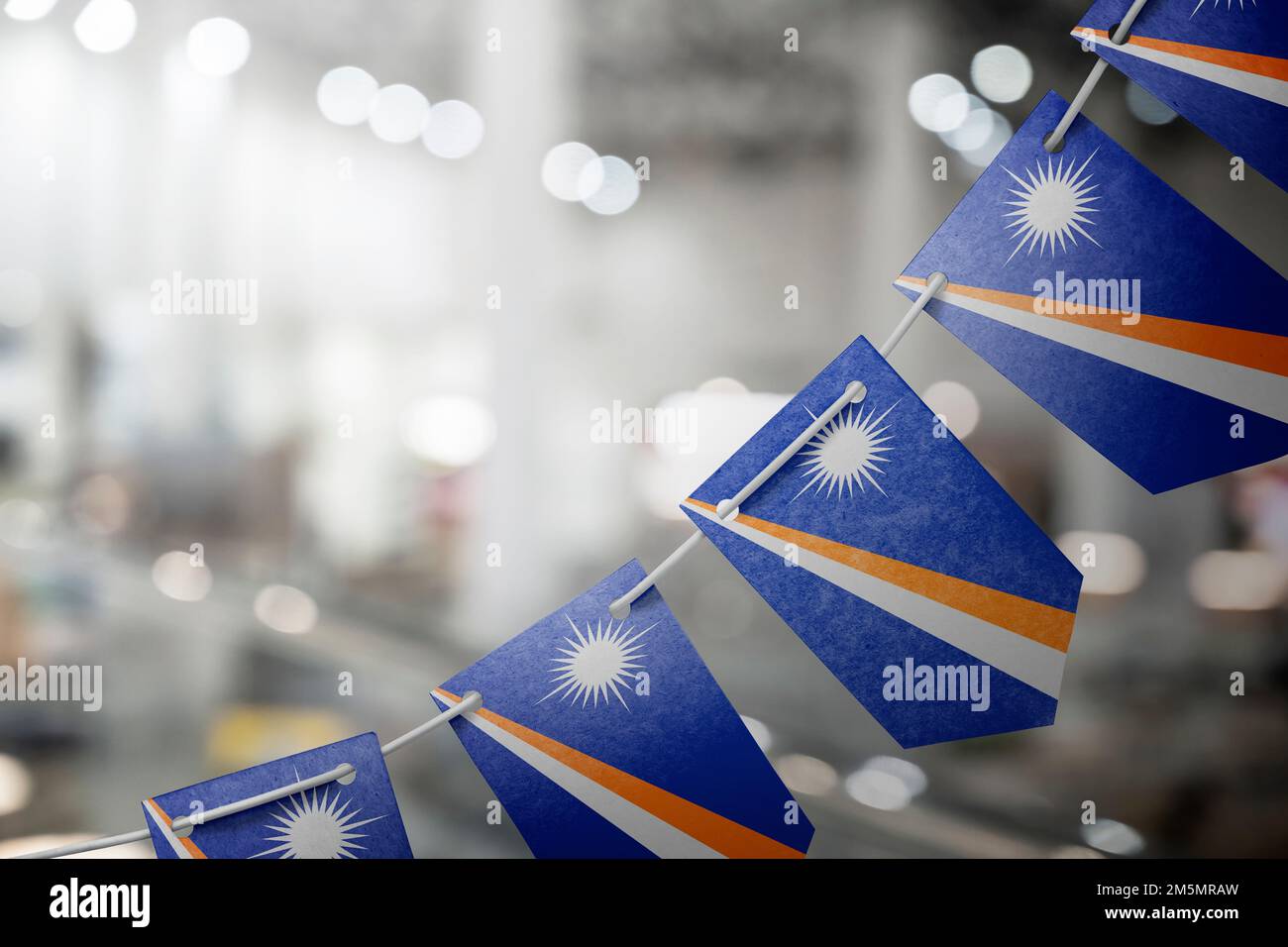 A garland of Marshall national flags on an abstract blurred background ...