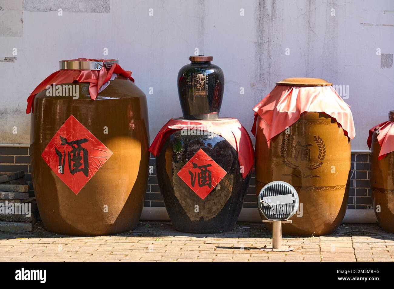 A st of vintage huge wine jars with Chinese sign text outdoor with ...