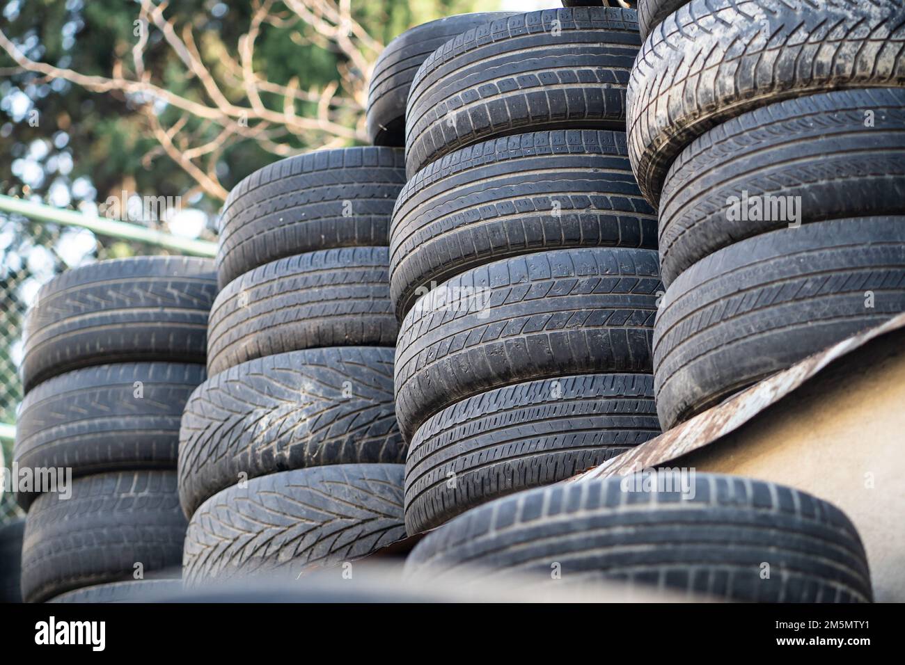 Old used rubber tires stacked with high piles. Hazardous waste ...