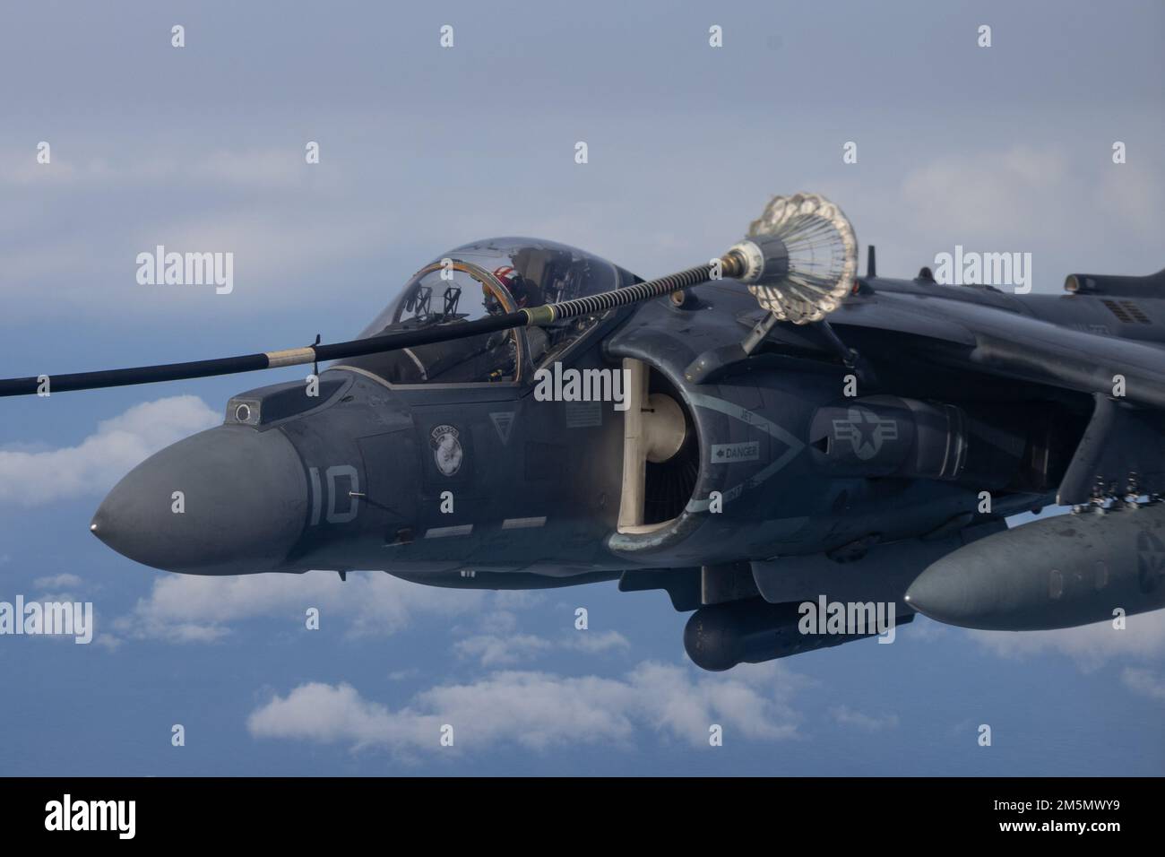 U.S. Marines use a KC-130J Super Hercules to refuel an AV-8B Harrier II ...