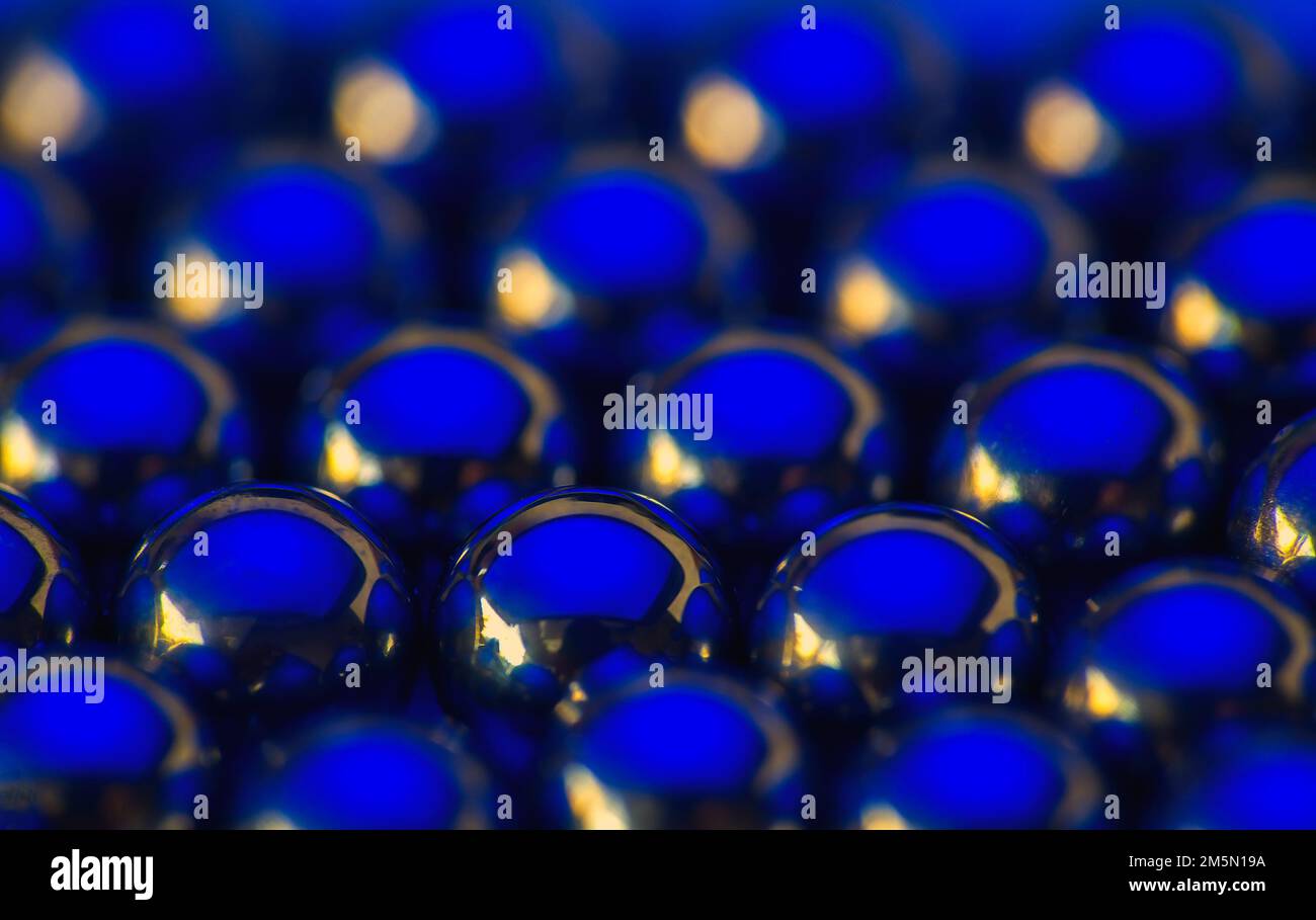 Metal small sphere shined with blue and gold light. Macro photo ...