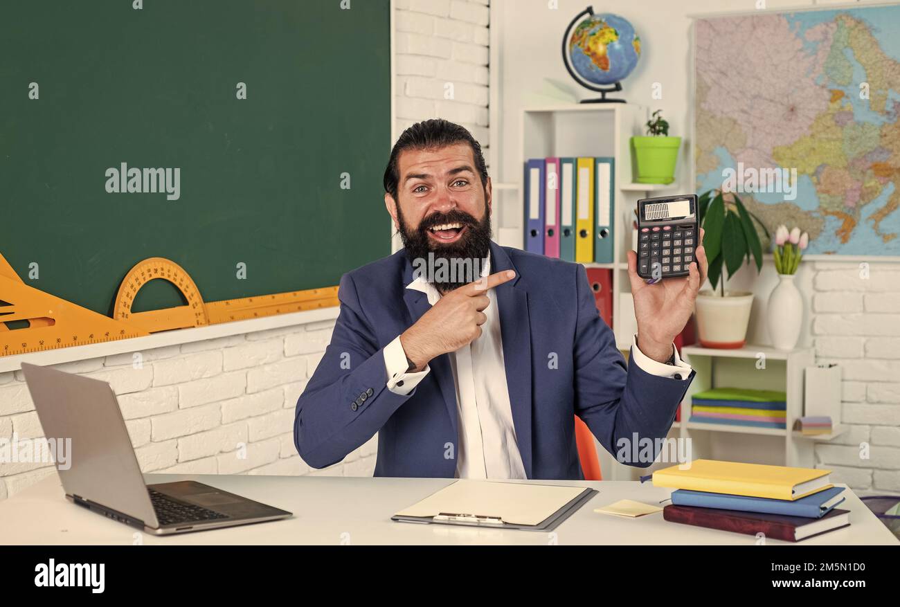 happy male with beard calculating on calculator in school math lesson ...