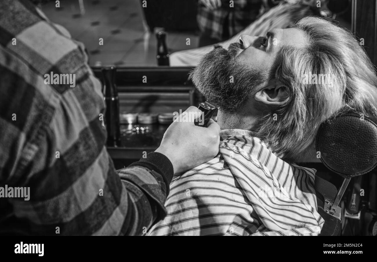 Bearded and stylish. hipster man with beard cutting his hair in a ...