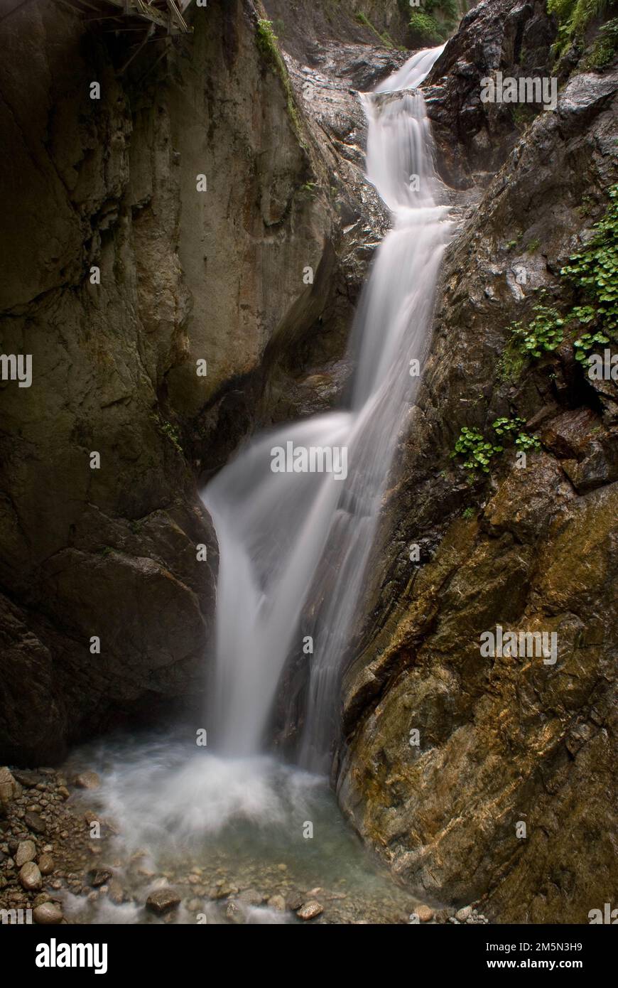 A long exposure shot of a cascade waterfall falling down the big rocks ...