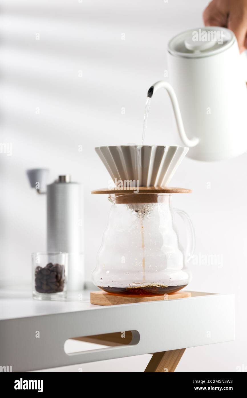 Pouring hot water through coffee grounds in a filter Stock Photo - Alamy