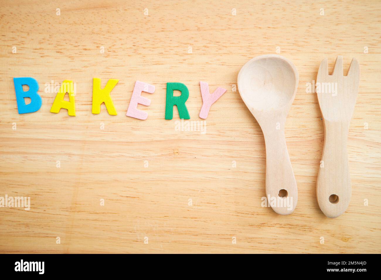 Wooden fork and spoon and Bakery word Stock Photo - Alamy