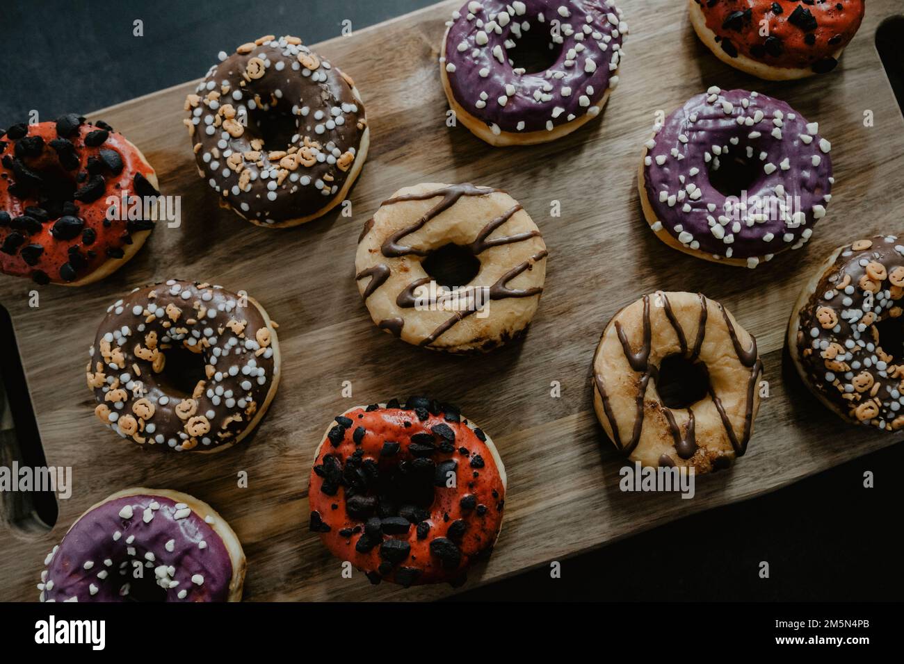 A top view of freshly baked donuts, glazed with chocolate and vanilla ...