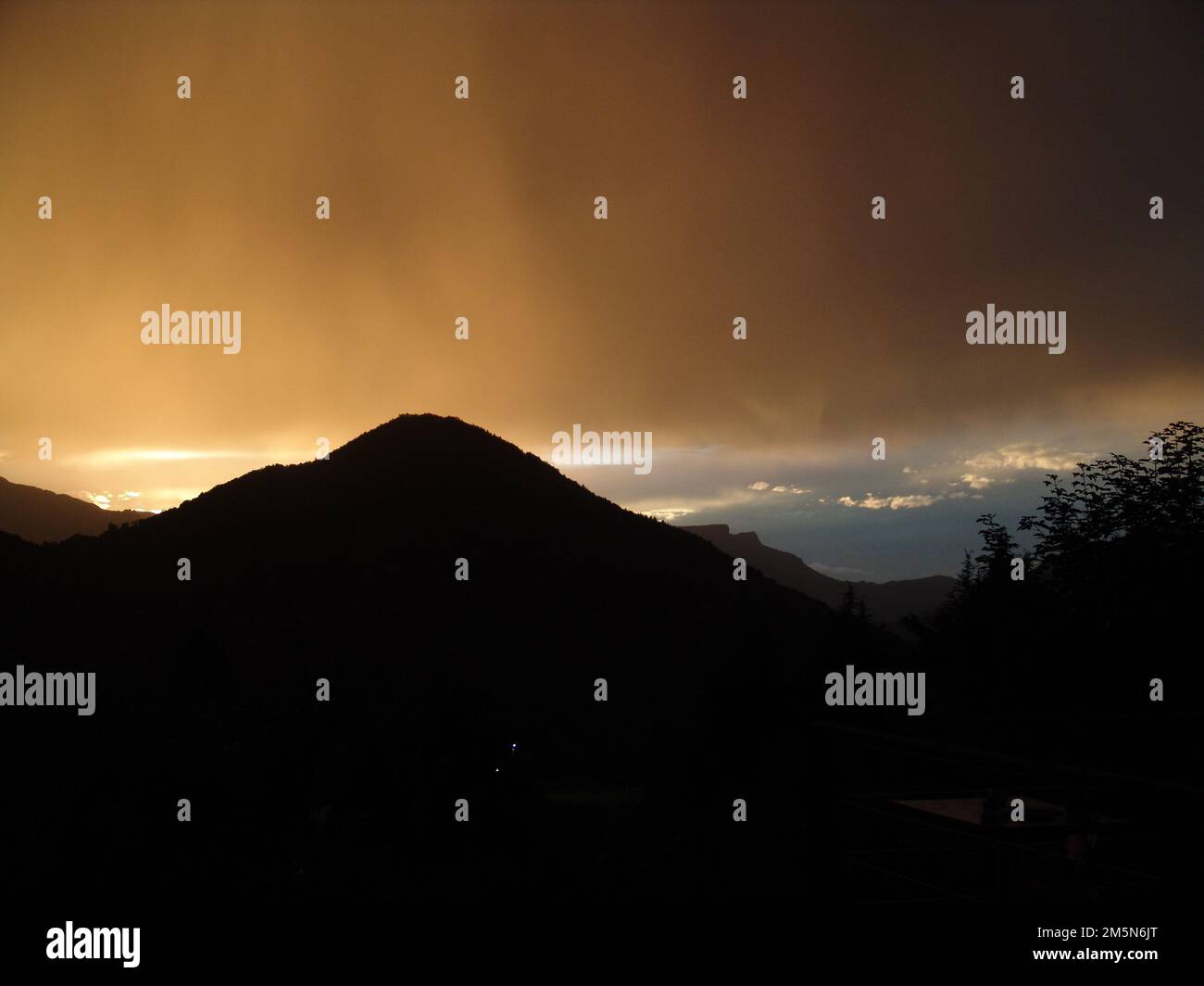A scenic view of silhouettes of mountains at sunset in the evening in a ...