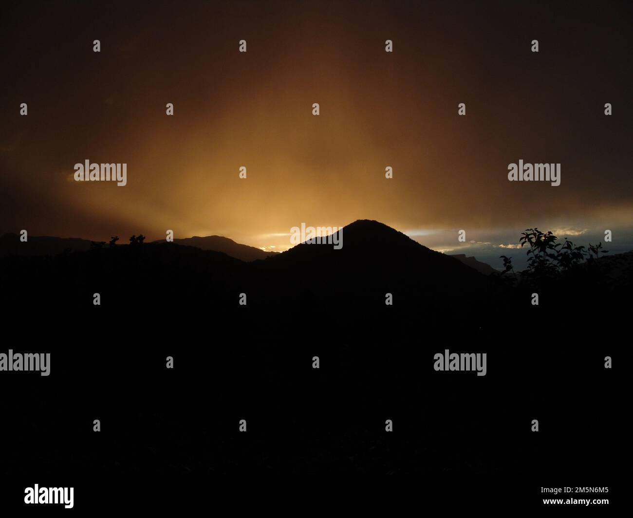 A scenic view of silhouettes of mountains at sunset in the evening in a ...