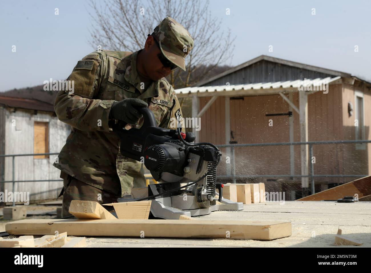 A U.S. Soldier, assigned to the 990th Engineer Company, nails plywood ...