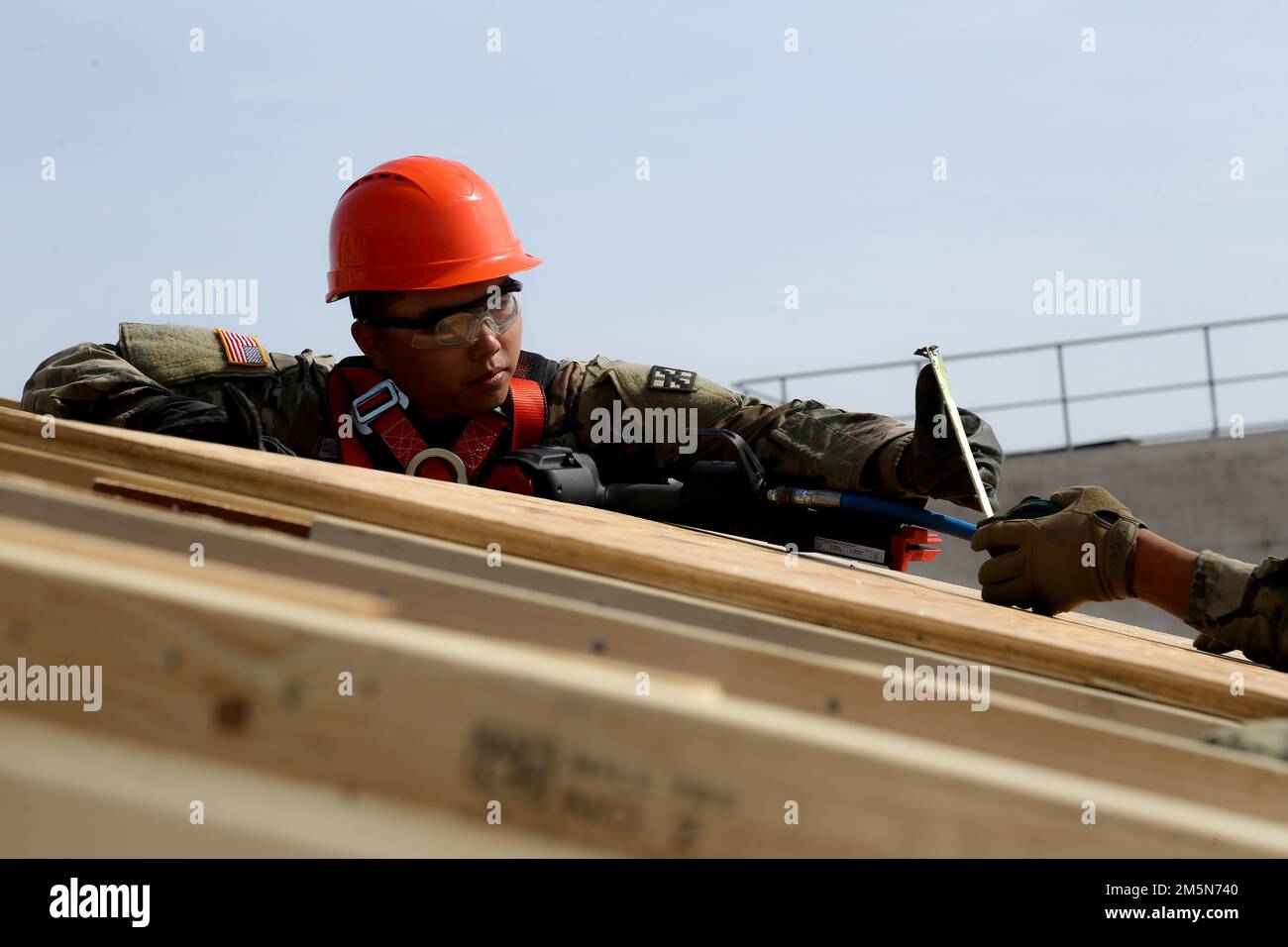 A U.S. Soldier, assigned to the 990th Engineer Company, nails plywood ...