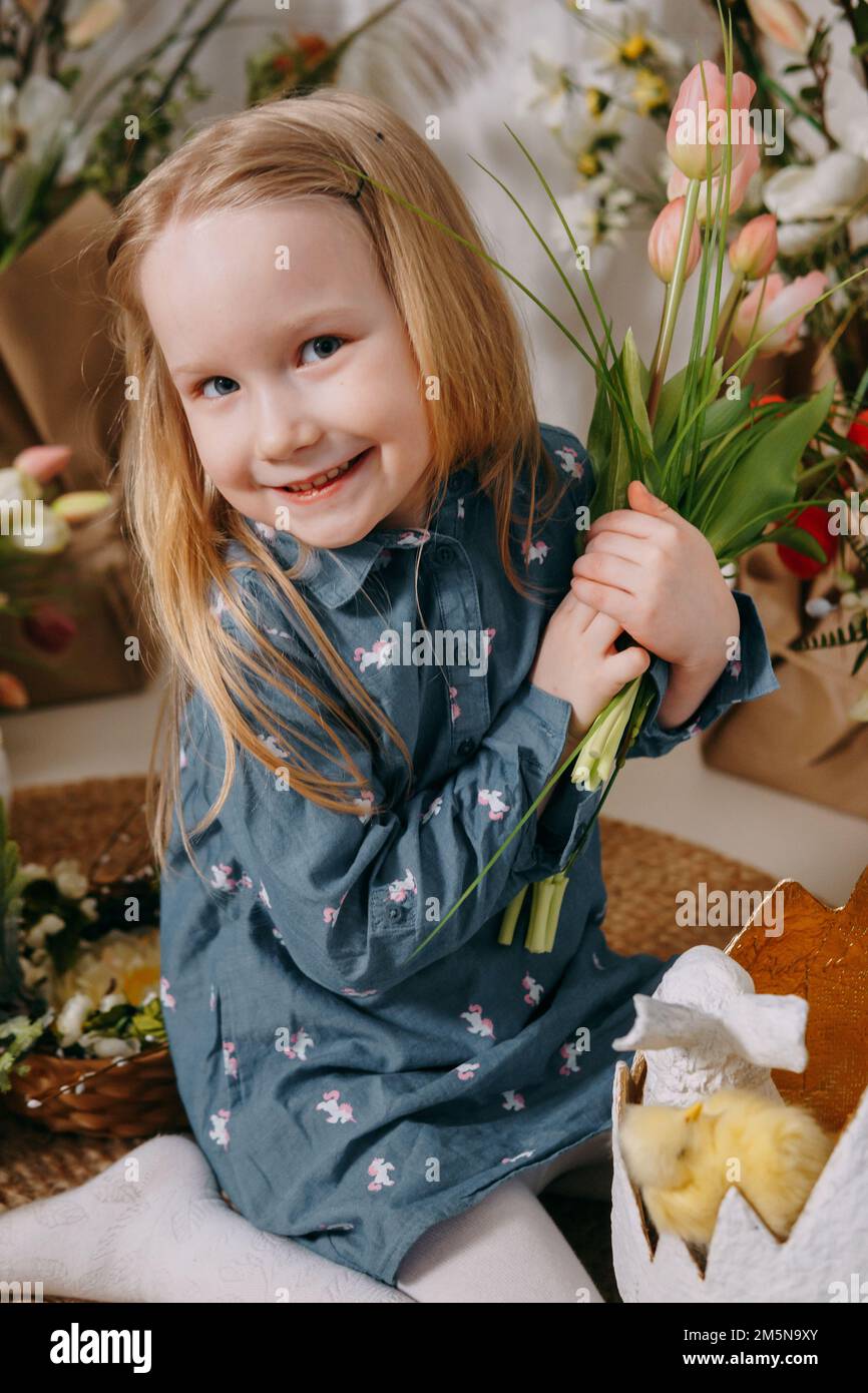 Two girls in a beautiful Easter photo zone with flowers, eggs, chickens ...