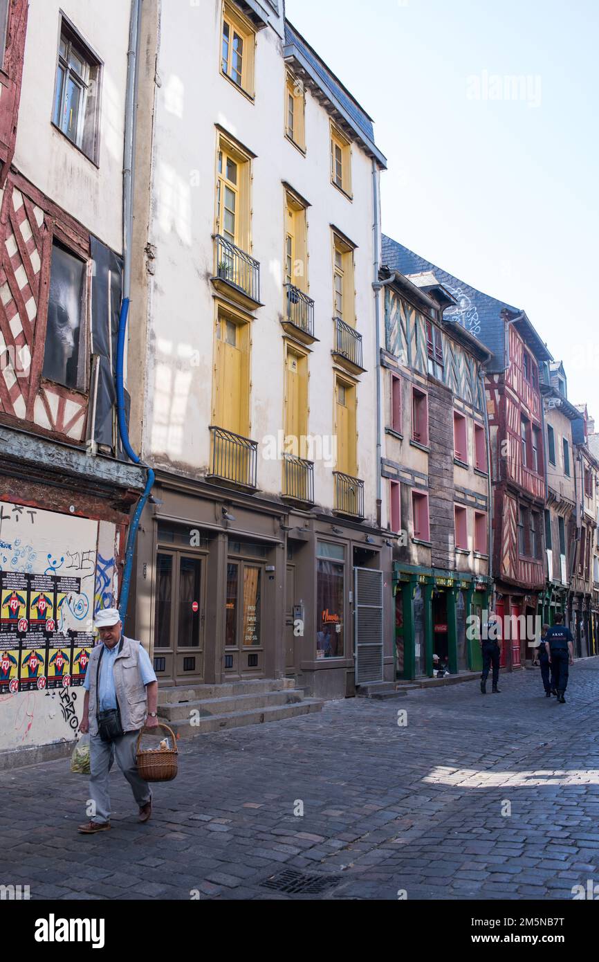 An old man carrying groceries in a street in Rennes with beautiful ...