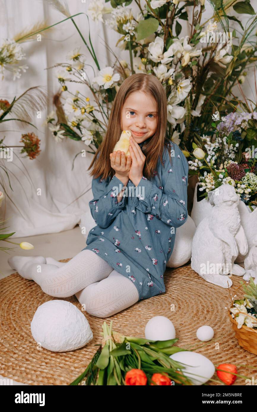 Two girls in a beautiful Easter photo zone with flowers, eggs, chickens ...