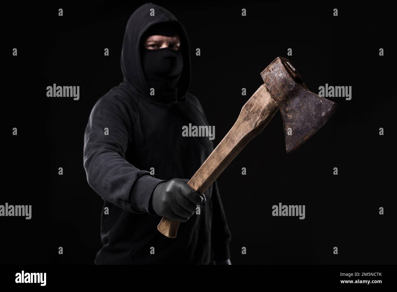 Bandit in black mask with hatchet on black background Stock Photo - Alamy