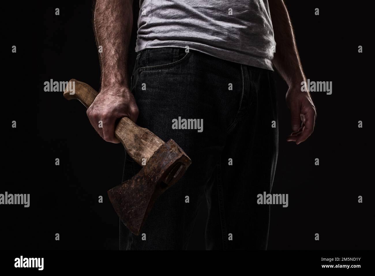 A man holds an ax in his hands against on black background Stock Photo ...