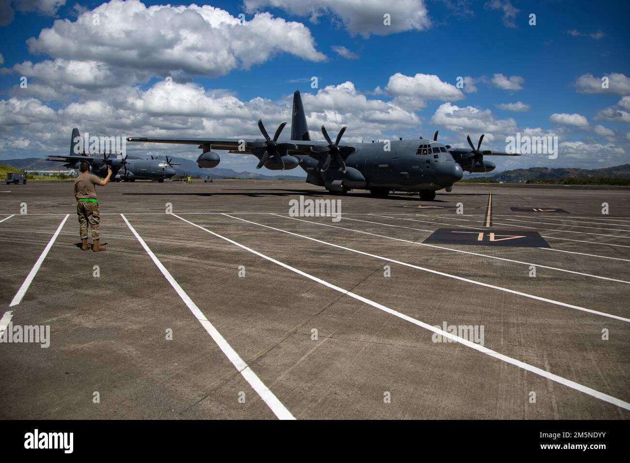 A U.S. Airman with the 353rd Special Operations Wing guides an MC-130J ...