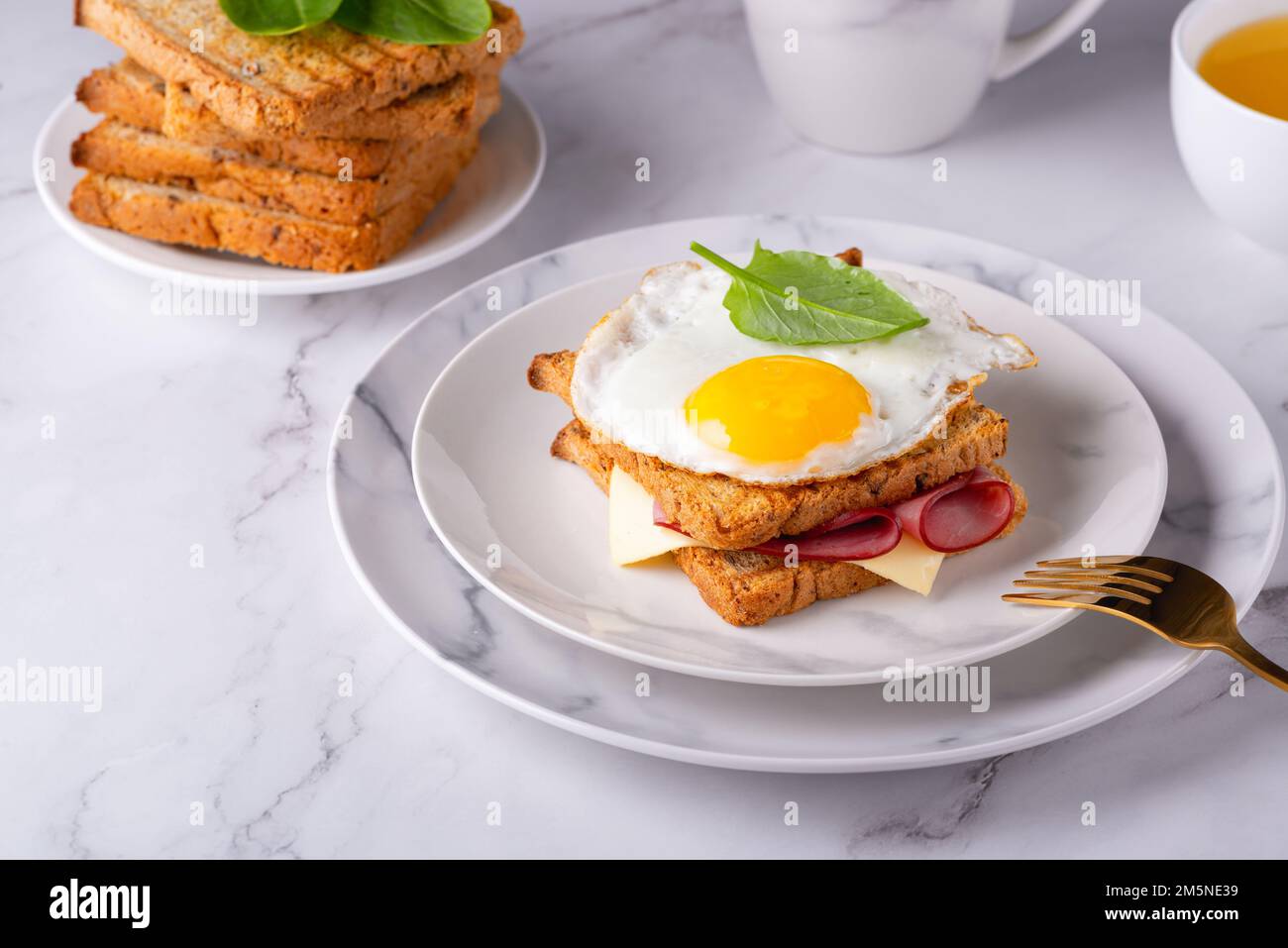 Slice of toasted bread with ham and fried eggs Stock Photo - Alamy