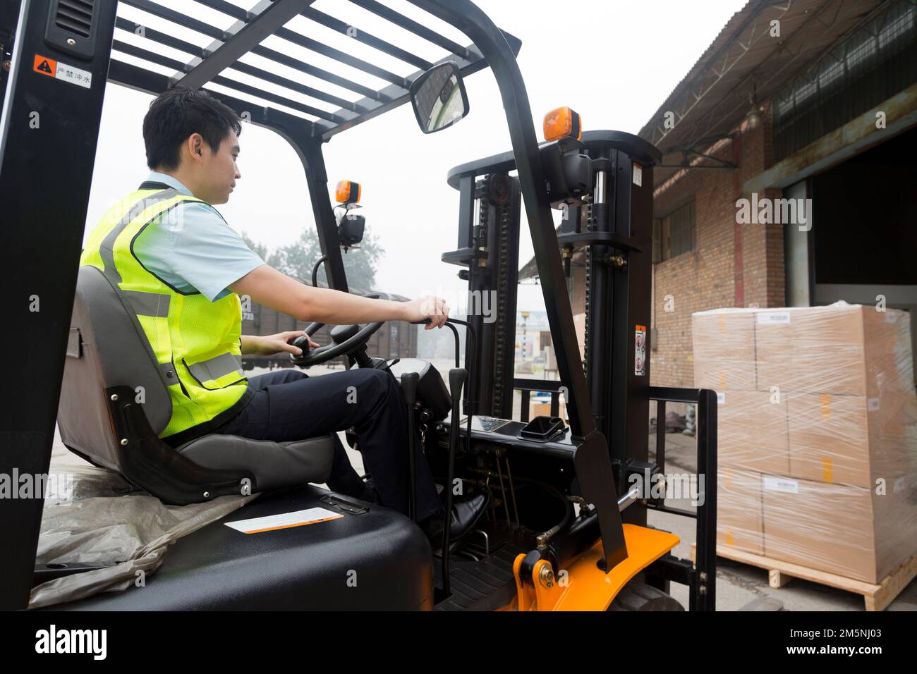 Logistics warehouse workers forklift driving Stock Photo - Alamy