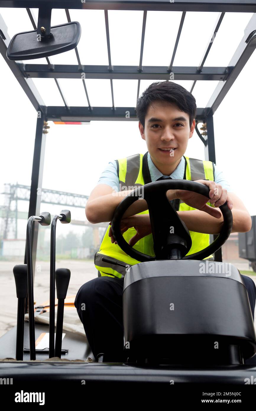 Logistics warehouse workers forklift driving Stock Photo - Alamy