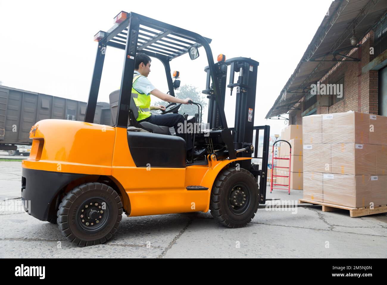 Logistics warehouse workers forklift driving Stock Photo - Alamy