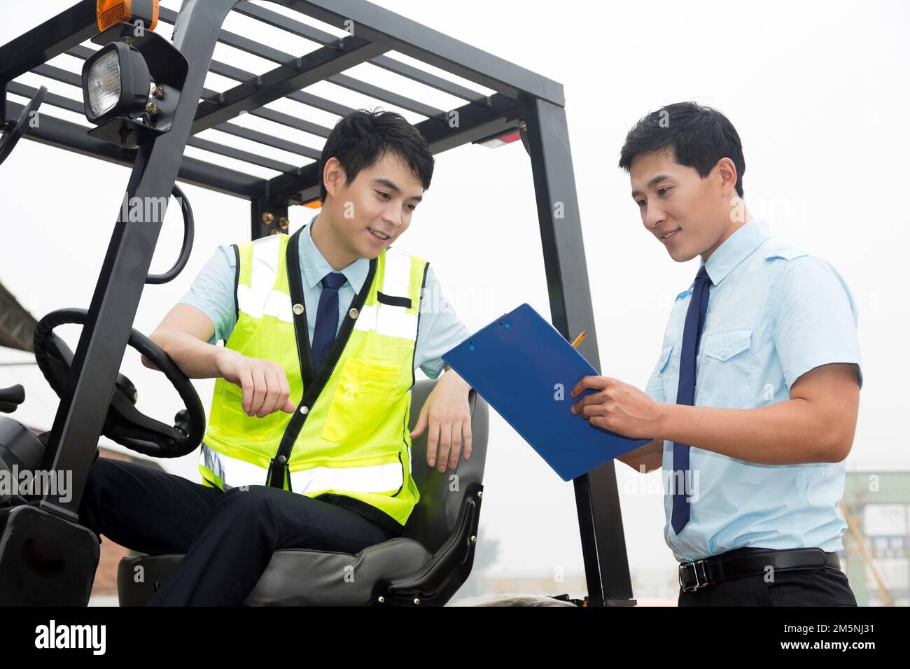 Logistics warehouse management personnel speak to drive a forklift ...