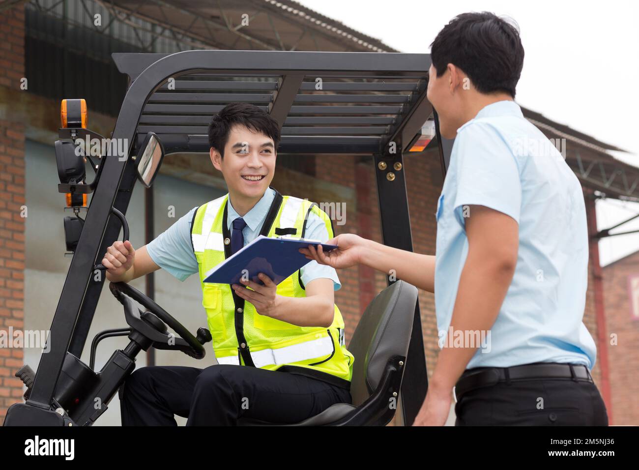 Logistics warehouse management personnel speak to drive a forklift ...