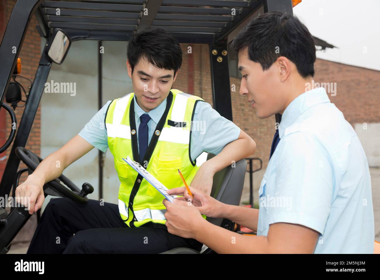 Logistics warehouse management personnel speak to drive a forklift ...