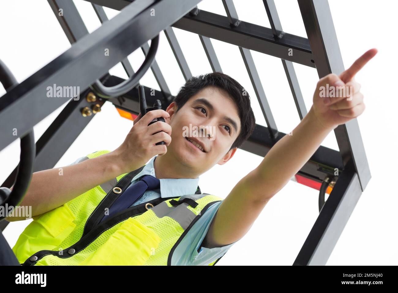 Logistics warehouse workers driving forklift truck, hand interphone ...