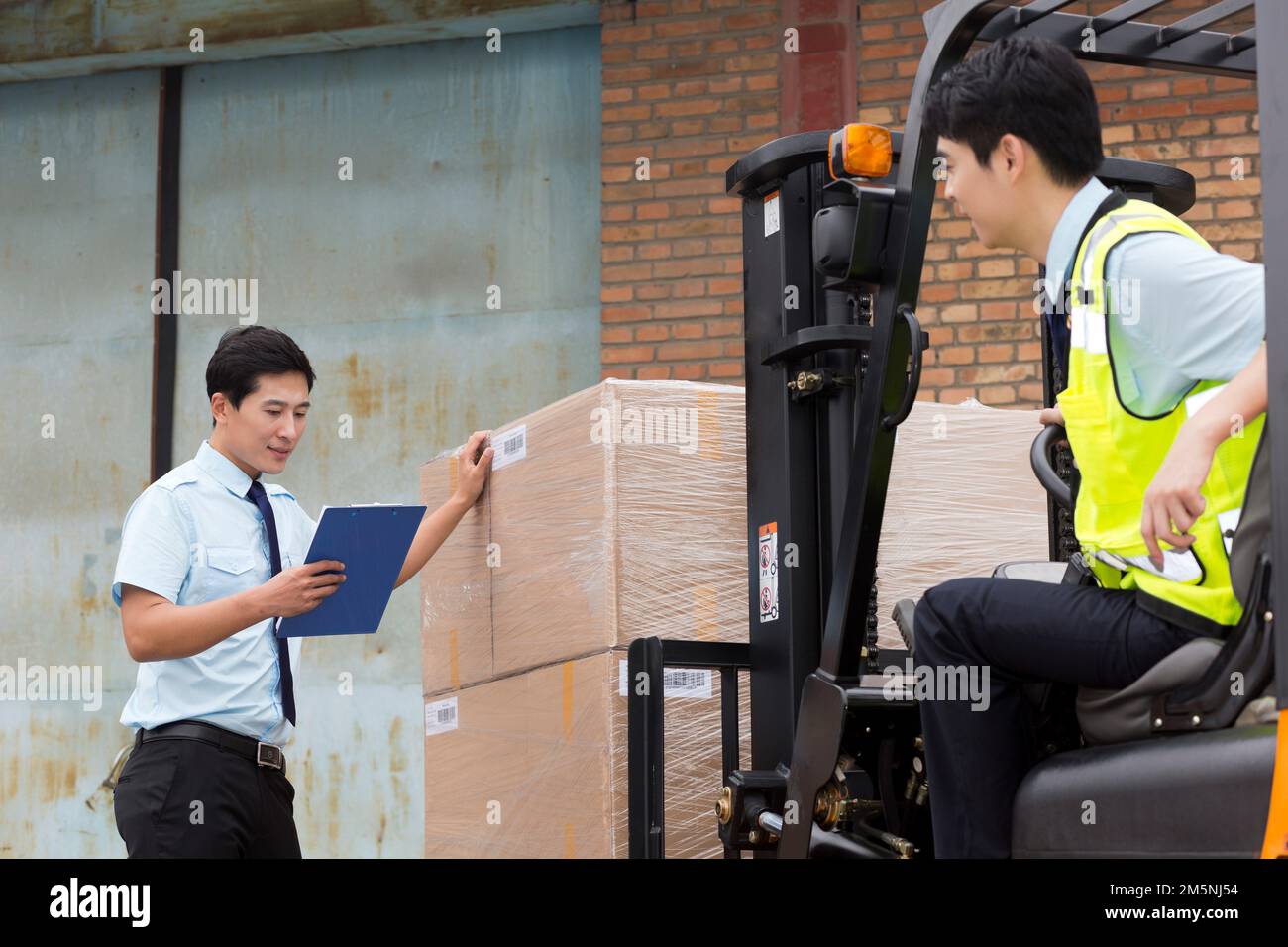Logistics warehouse management personnel communicate with driving a ...