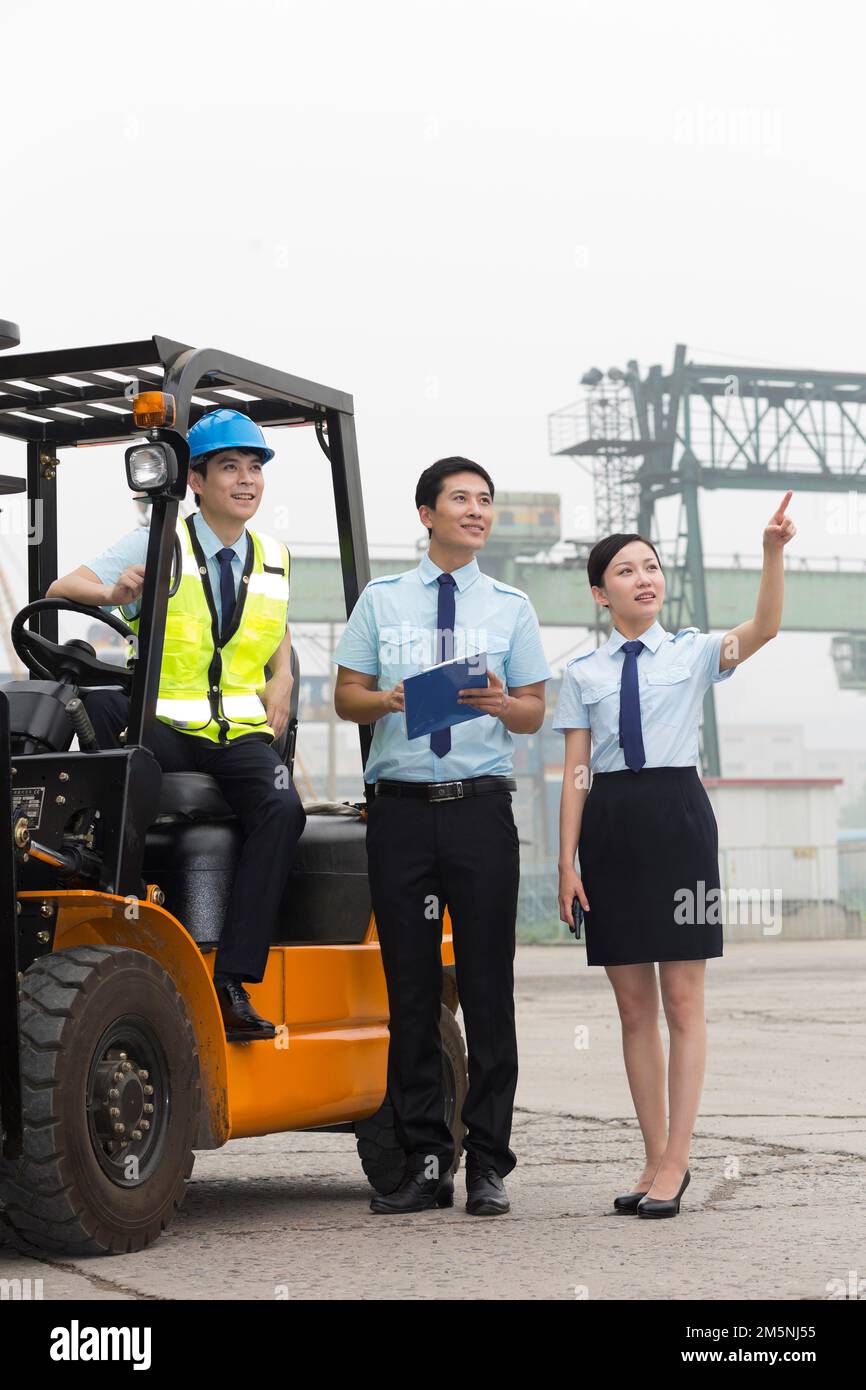 Logistics warehouse management personnel communicate with driving a ...