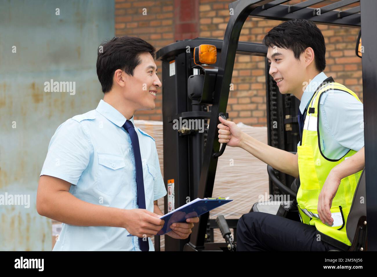 Logistics warehouse management personnel speak to drive a forklift ...