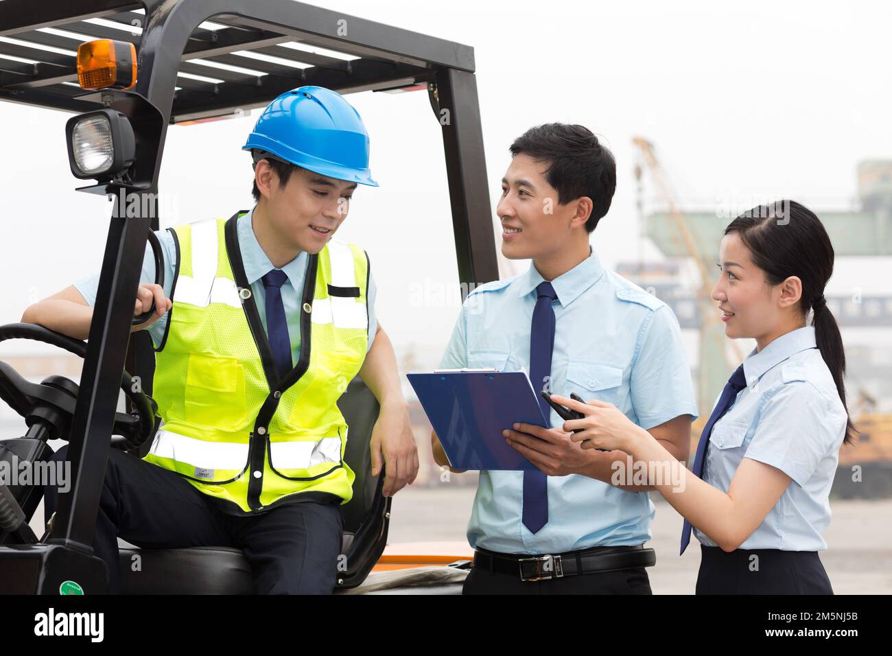 Logistics warehouse management personnel communicate with driving a ...