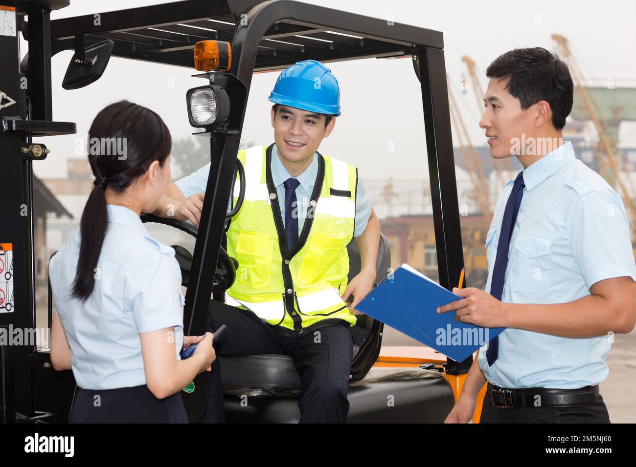 Logistics warehouse management personnel communicate with driving a ...