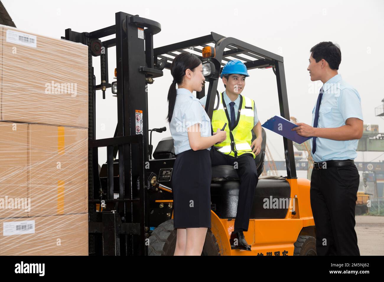 Logistics warehouse management personnel communicate with driving a ...