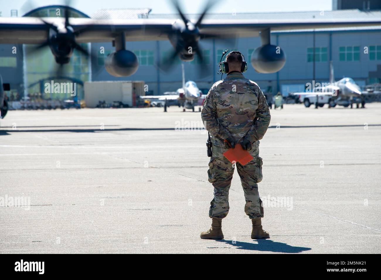 A crew chief from the 129th Rescue Wing directs a HC-130J Combat King ...